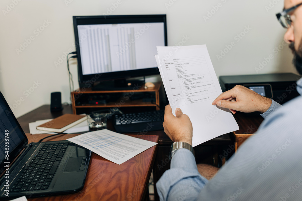 Man working with paper documents at his desk Stock Photo | Adobe Stock
