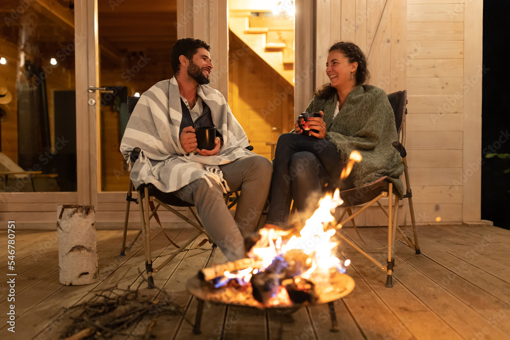 Happy people sitting next to the fire at night time Stock Photo | Adobe ...