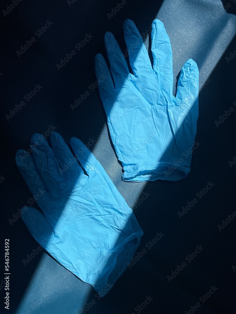 Blue plastic gloves on the blue background of sunlight Stock Photo ...