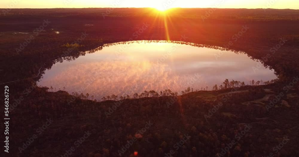 Fog on a lake. Top down view of a golden orange sunlight moving on a ...