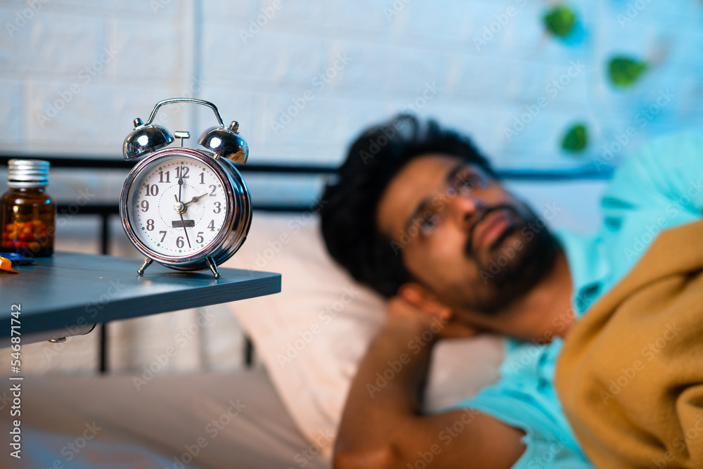 young man unable to sleep during night at bedroom - concept of ...