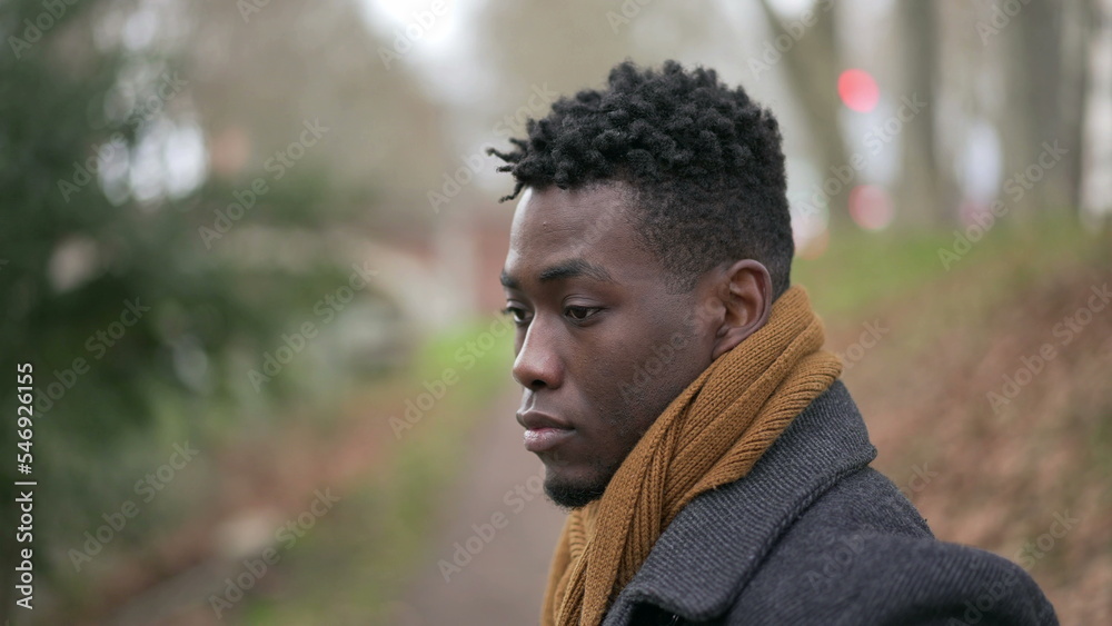 Contemplative young black man standing outside in nature park Stock ...