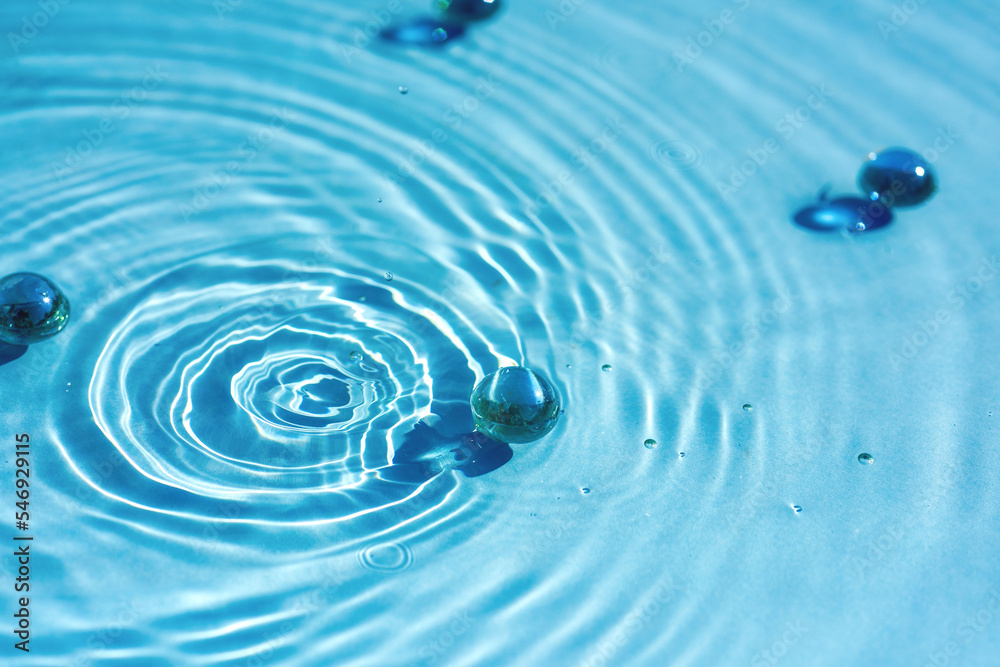 Circles and on the surface of blue water, ripples, water background ...