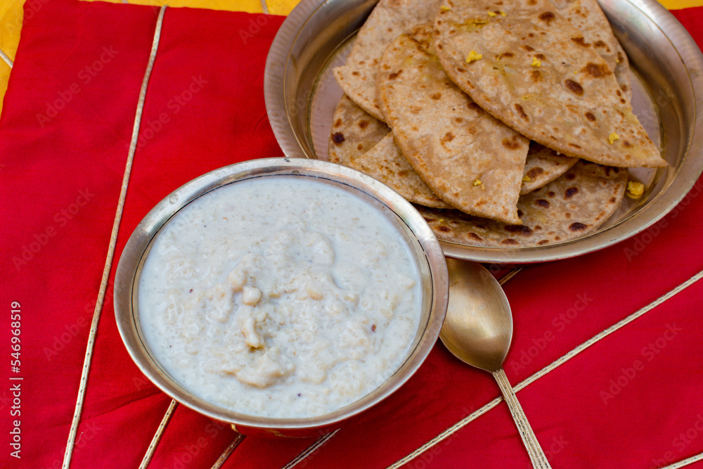 Dal Puri or dal stuffed paratha in brass plate and Gur kheer or kheer ...