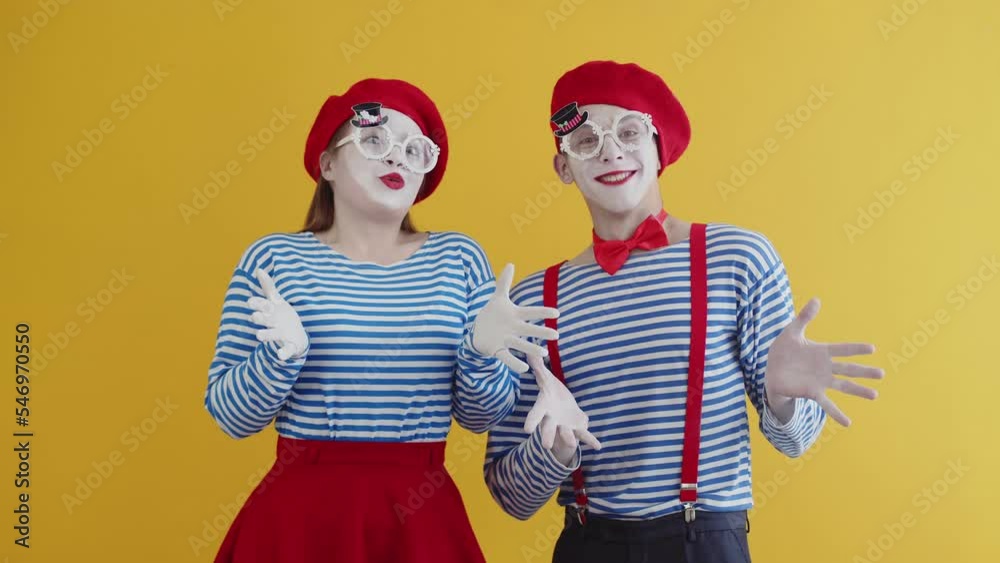Pantomimes makes a performance on a yellow background. A man mime and a ...