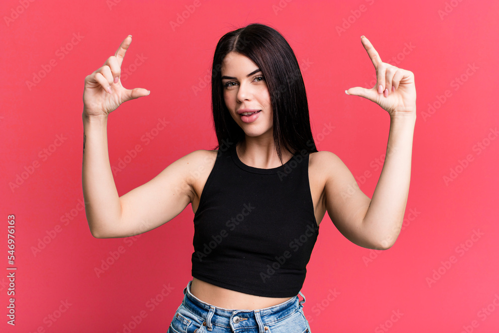 young adult pretty woman framing or outlining own smile with both hands ...