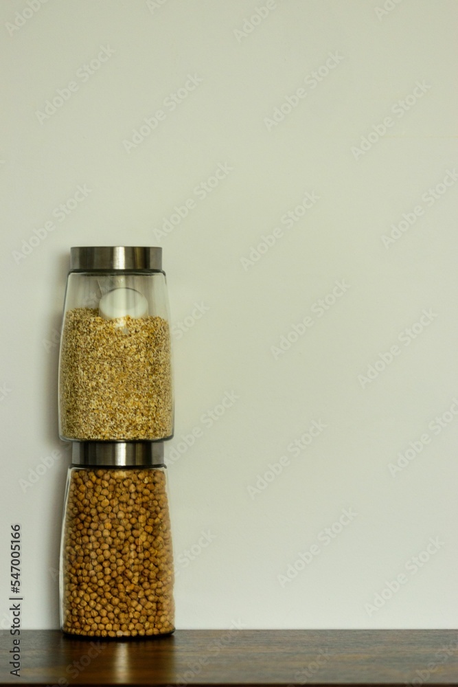 Vertical view of two clear glass food storage Canisters stacked on top ...