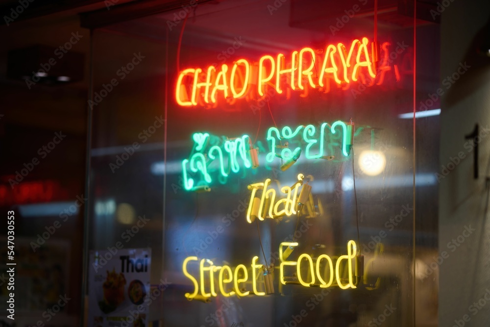 Illuminated neon sign of a Thai cuisine street food restaurant in ...