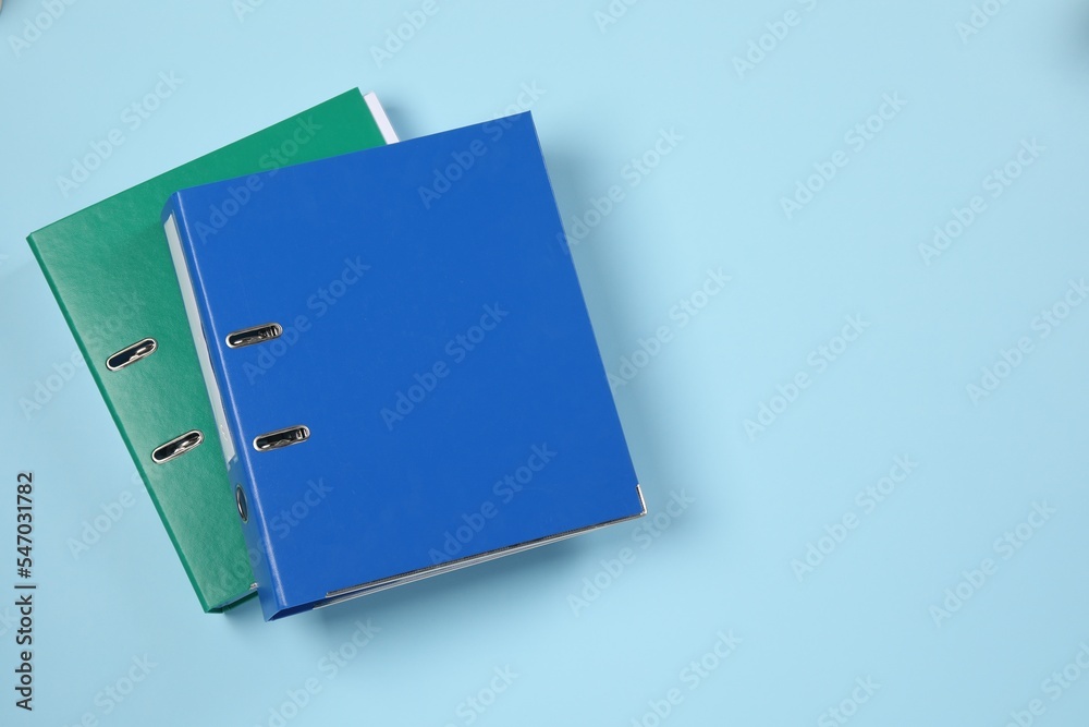 Office folders on light blue background, flat lay. Space for text Stock ...
