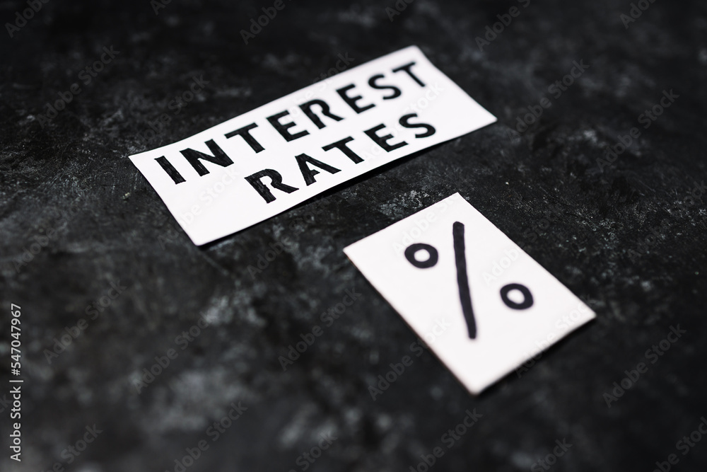 Interest rates text with percentage symbol on dark background, economic ...