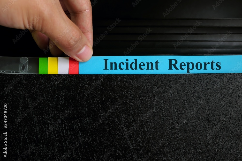 Hand picking incident report file in black binder folder. Corporate ...