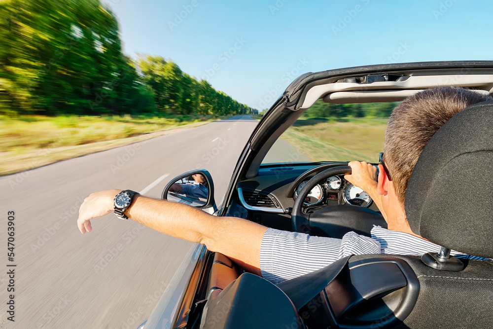 calm happy successful man sit in car hand is driving the car on the ...