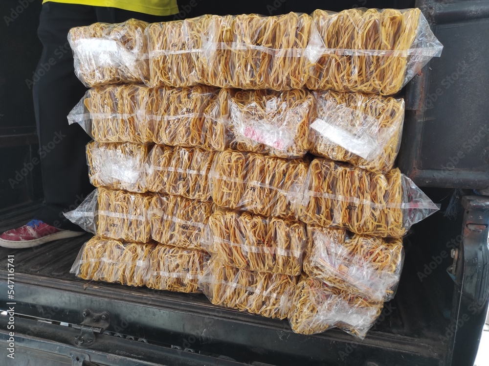 pile of instant noodles in plastic packaging, in a box car, which is ...