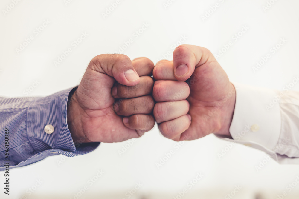 Foto de Shot of two unrecognizable businesspeople giving a fist bump ...