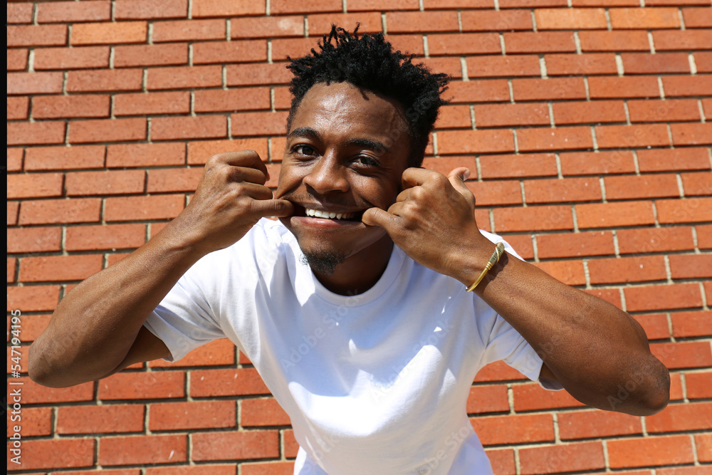African American man with dread fade haircut showing a fake smile, fish ...