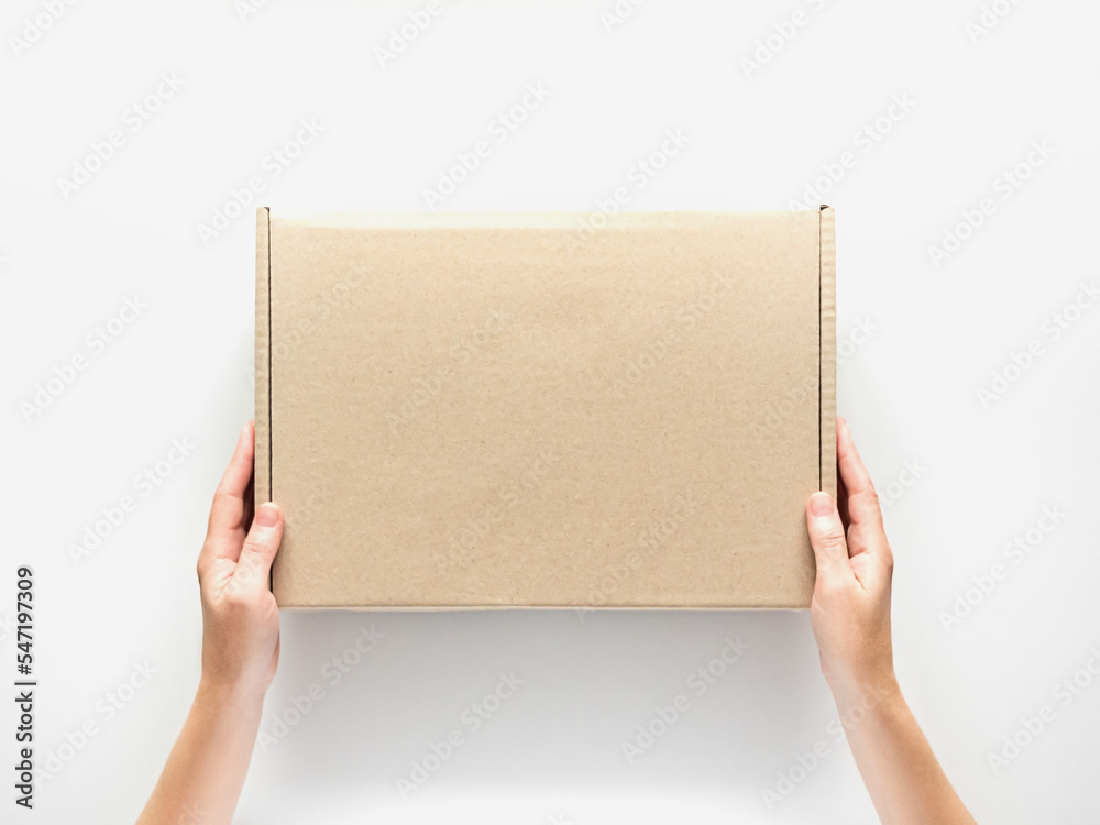 female hands holding a cardboard box on a white background. packaging ...