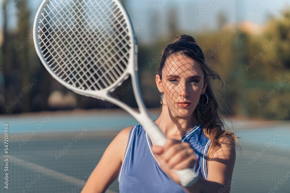 Young attractive fit caucasian female posing with a tennis racket on a ...