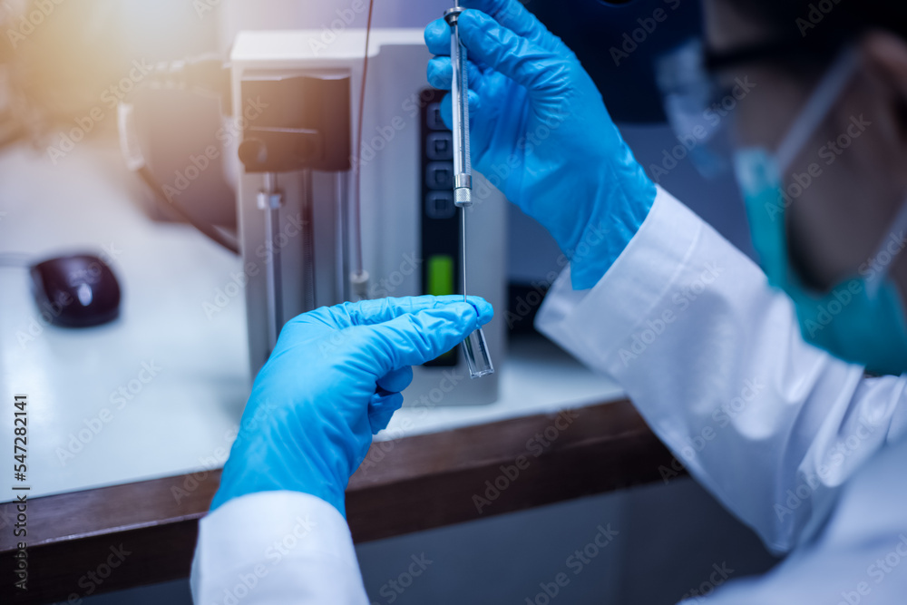 Scientist inject sample with micro syringe to TOF Mass Spectrometer for ...