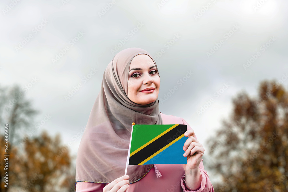 Muslim woman in hijab holds flag of Tanzania Stock Photo | Adobe Stock