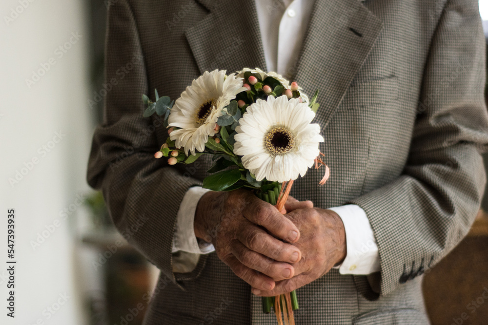 Old man in love carrying a bouquet of flowers. Jacket dress. Love in ...