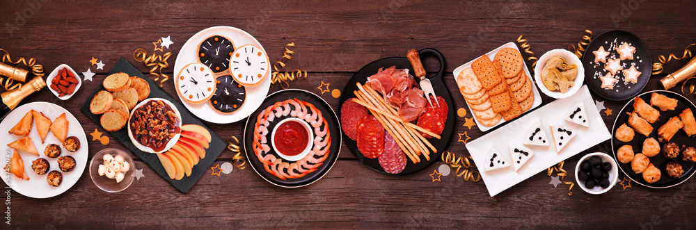 New Years Eve theme appetizer table scene. Top view on a dark wood ...