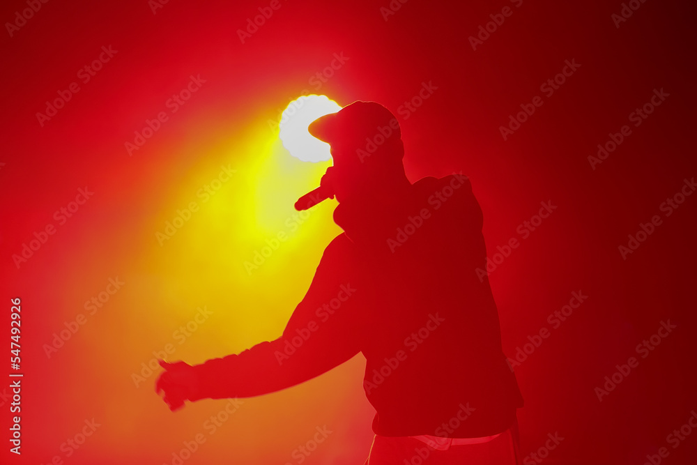 Silhouette of rap singer with microphone. Cool rapper with mic in hand ...