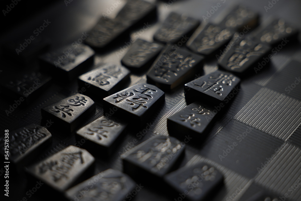 Piece of Shogi (made of titanium) on titanium plate. Shogi is the ...