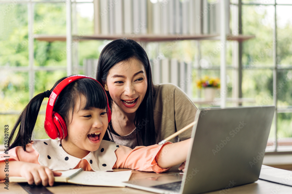Mother and asian kid little girl learn and look at laptop computer ...