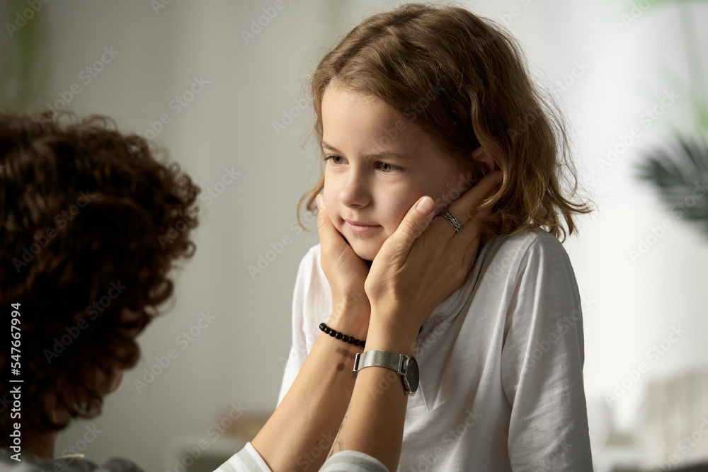 Little boy listening and talking to his mom while she showing her care ...