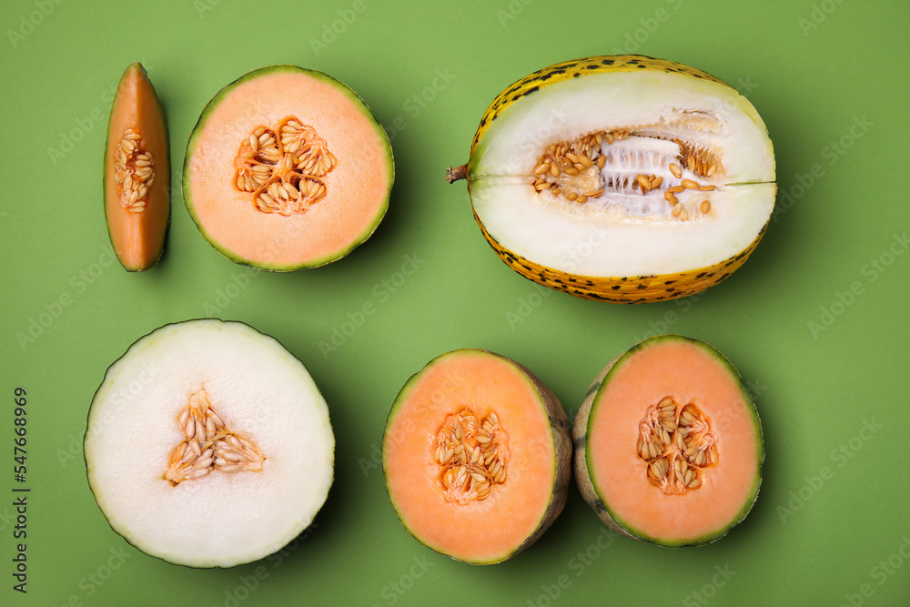 Poster Cut different types of melons on green background, flat lay ...