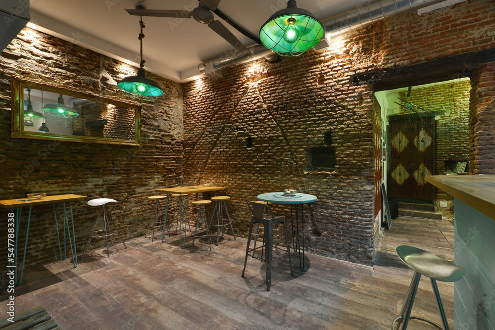 Hall of a bohemian bar with wooden tables, wooden floors and exposed ...