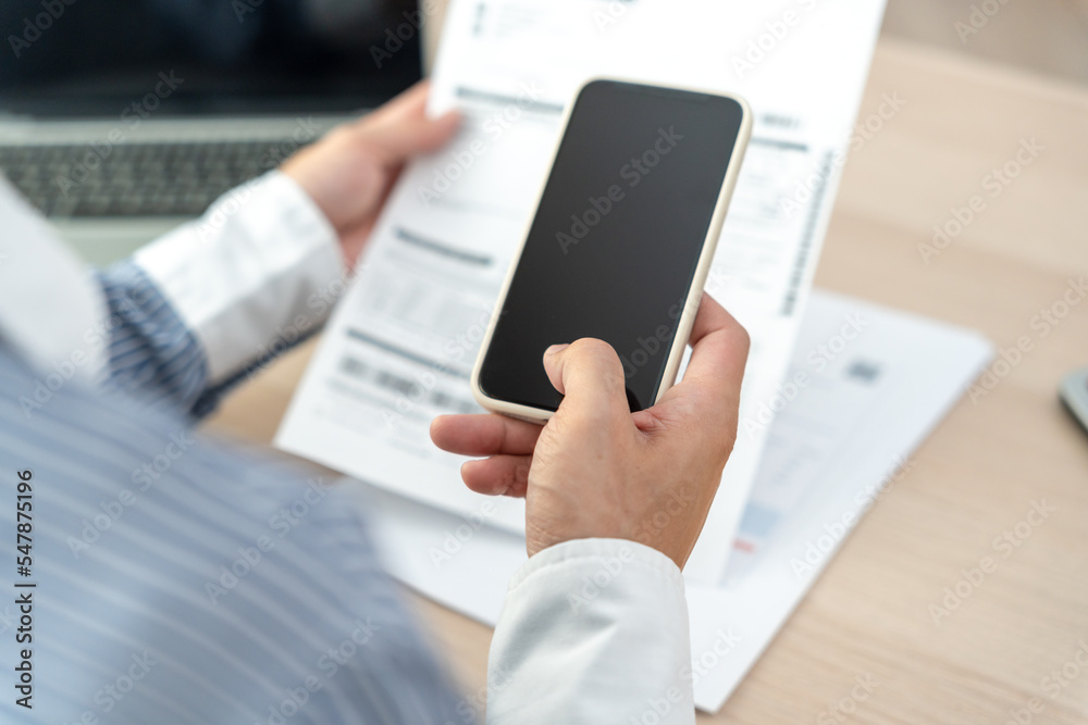 business man uses his phone to scan barcode or QR codes to pay his ...