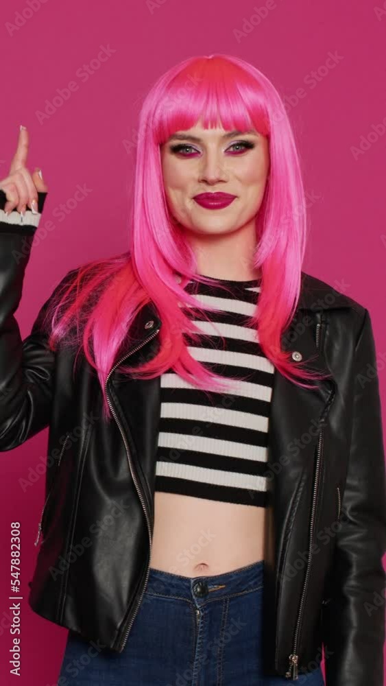 Vertical video: Trendy female model pointing up with index fingers on ...