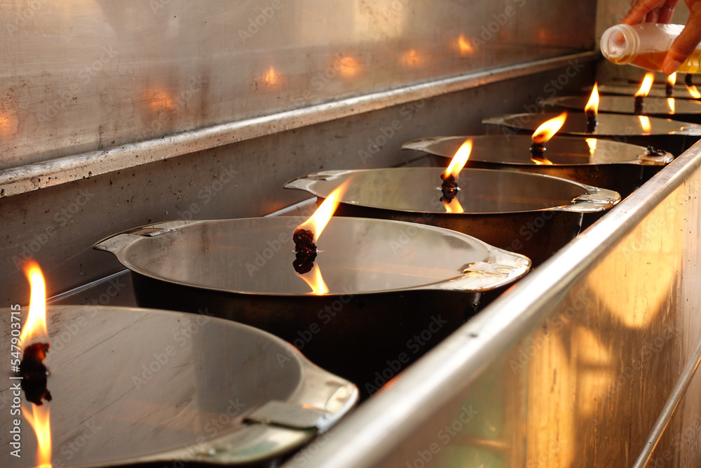 Hand is pouring oil into lamp to make a wish,Add oil to lamp,Buddhist ...