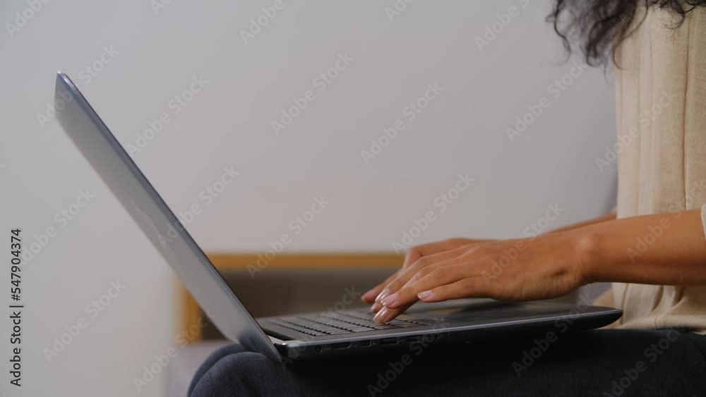 Female programmer coding on laptop. Dark skinned woman typing text on ...