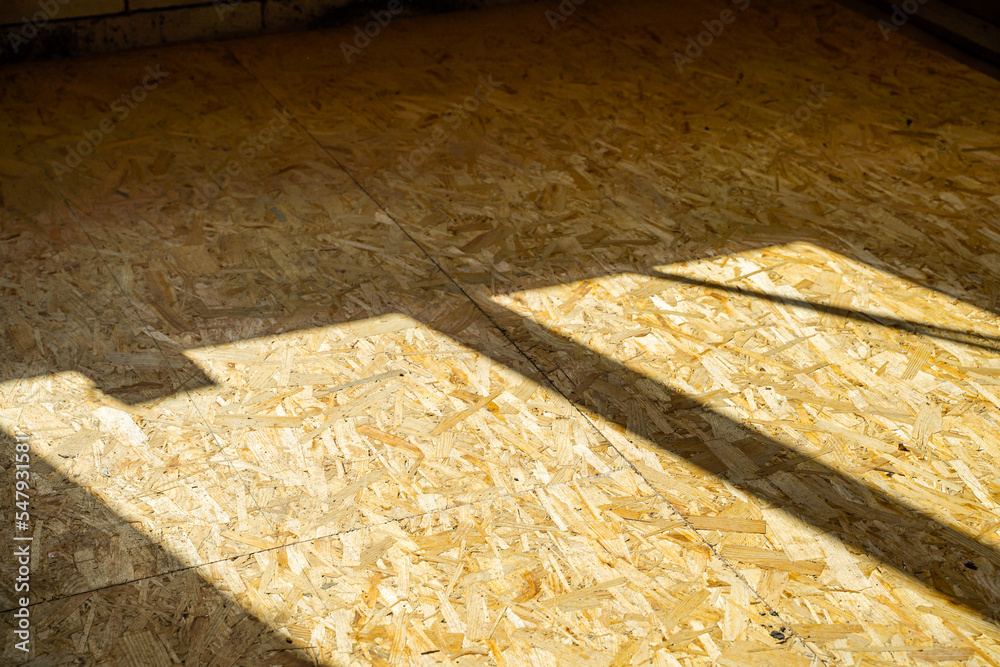 Shade from the sun on the floor of osb panels. Shadow from the window ...
