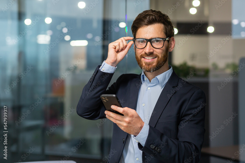 Portrait successful boss with a phone, a man in glasses and a business ...