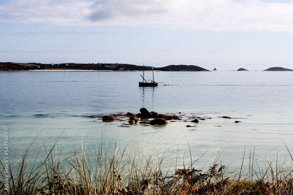 Beach with a sail boat offshore on the Isle of St Martins in the Scilly ...