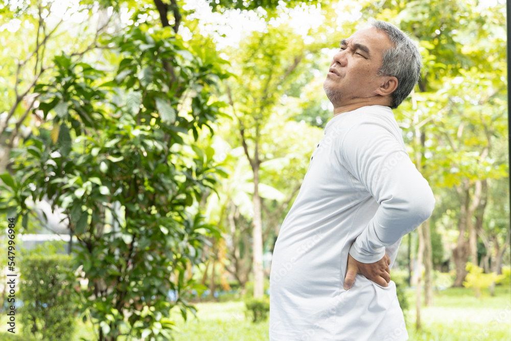 old Asian senior man suffering from lower back pain, herniated disc ...