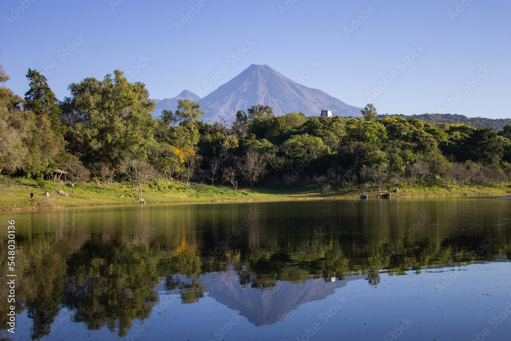 Foto de un enorme volcán reflejándose en una hermosa laguna, un buen ...