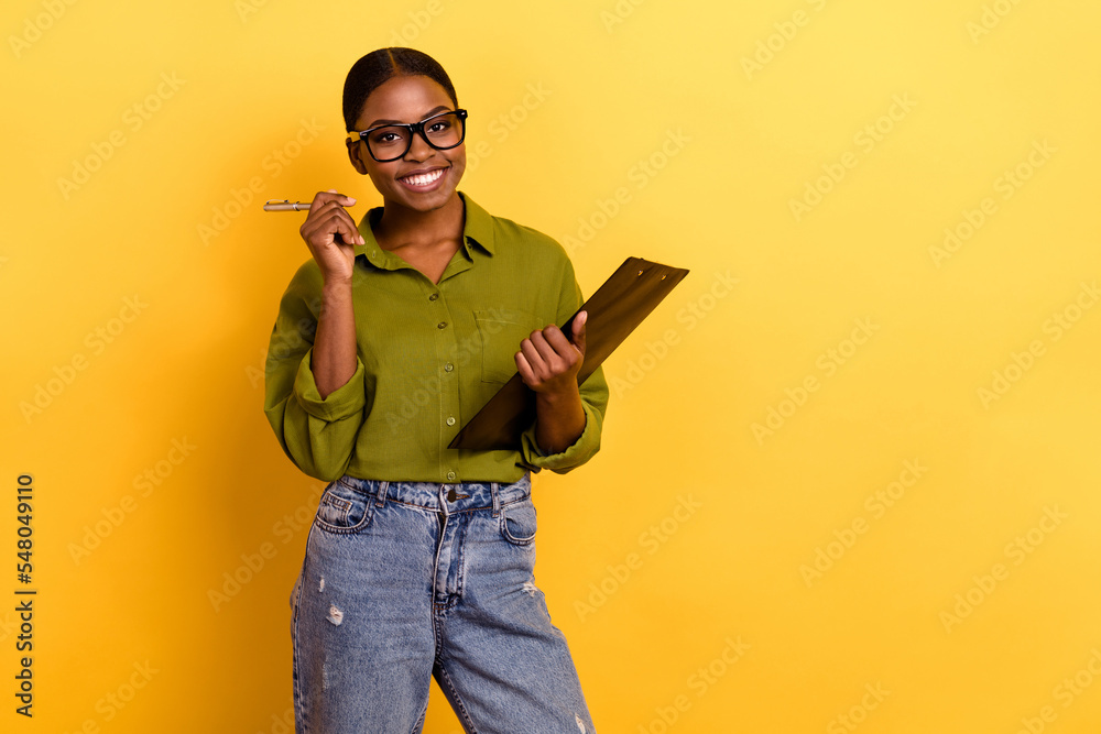 Portrait of attractive cheerful girl holding clipboard signing paper ...