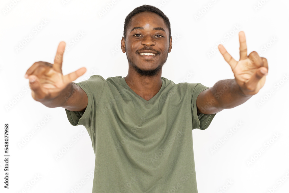 Cheerful young man making peace signs with both hands. Male African ...