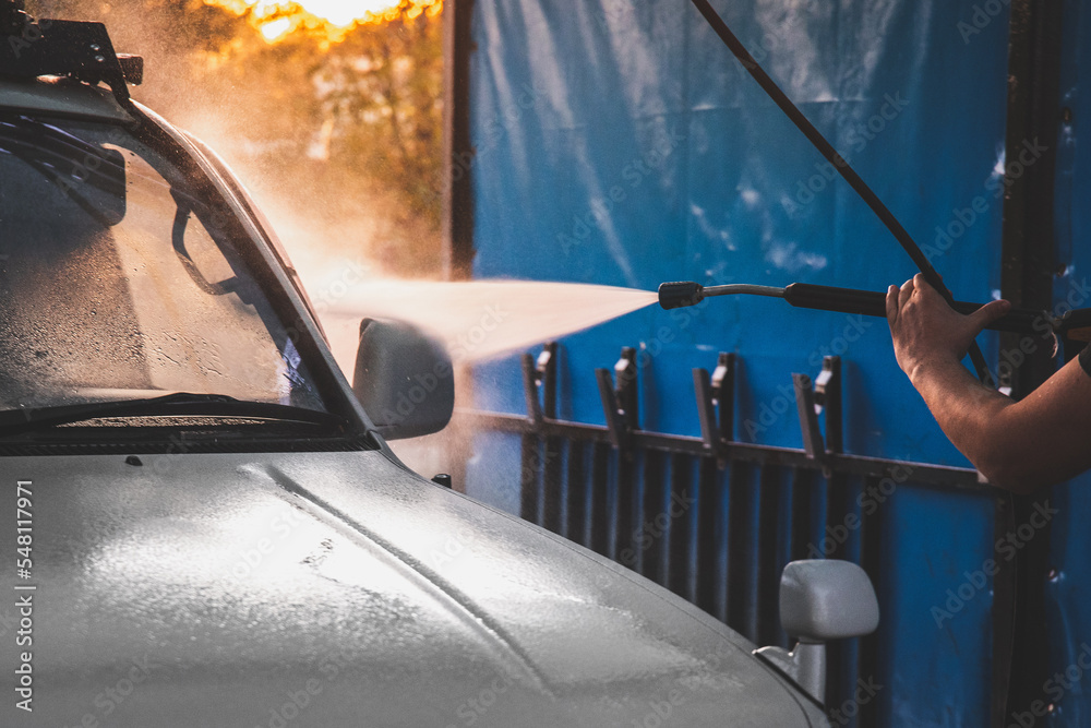 Human hand washing white car on contactless self-service car wash with ...