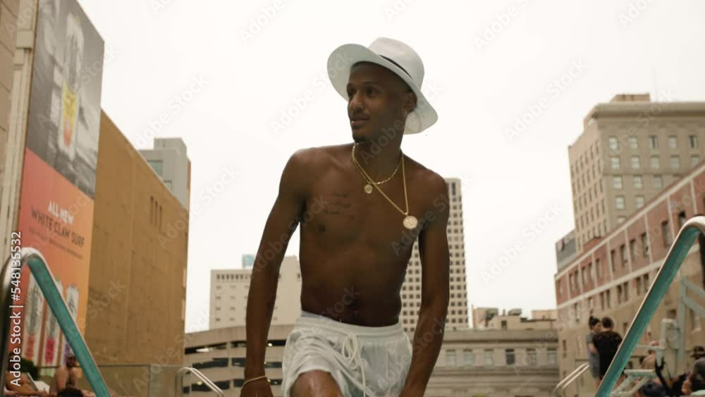 Vidéo Stock Attractive man wearing fedora hat and gold jewelry exits ...