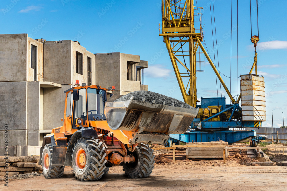 Bulldozer or loader at the construction site transports gravel or ...