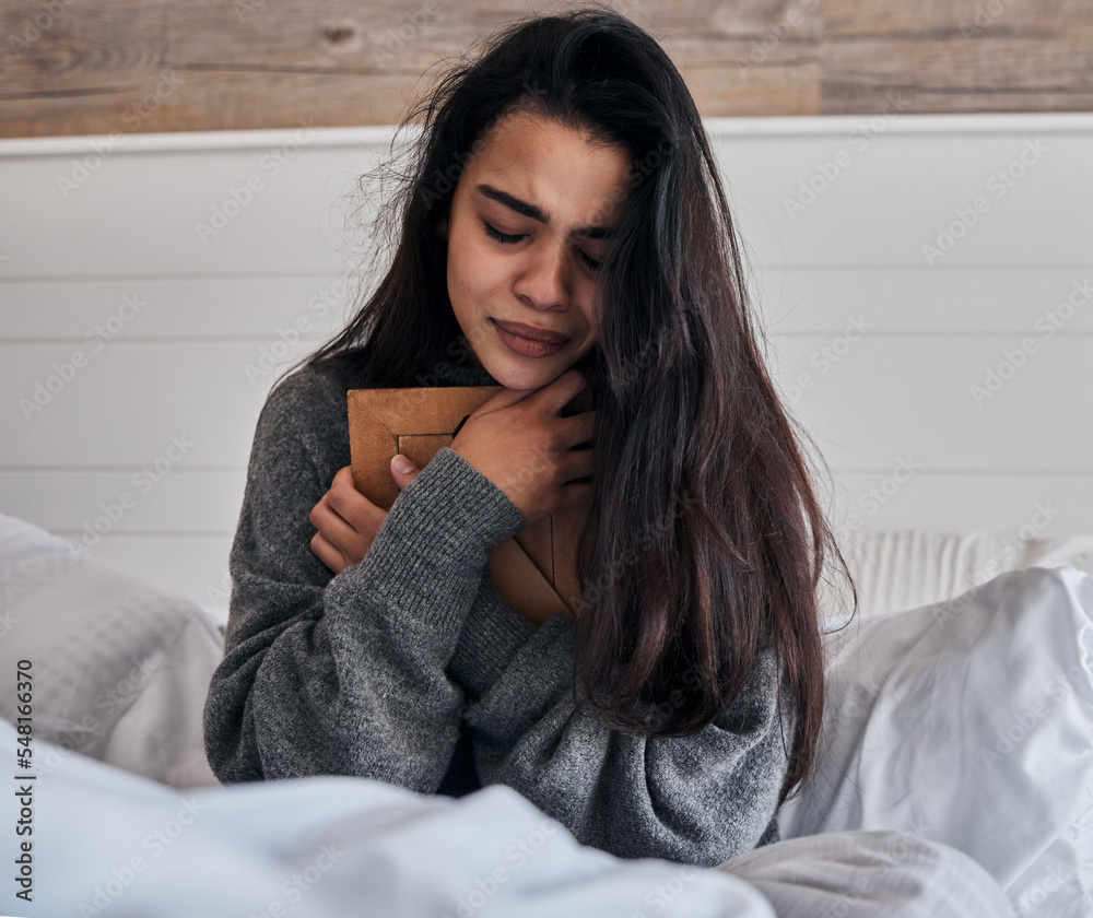 Sad, loss and woman crying with a photo for memory while in bed in the ...