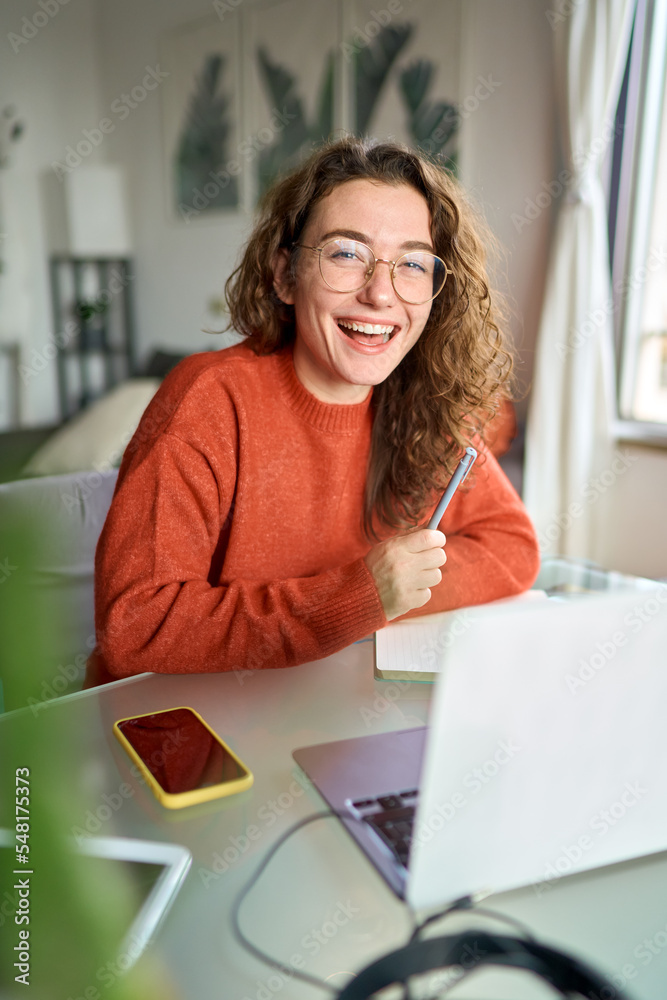 Happy young woman student laughing using laptop sitting at desk ...