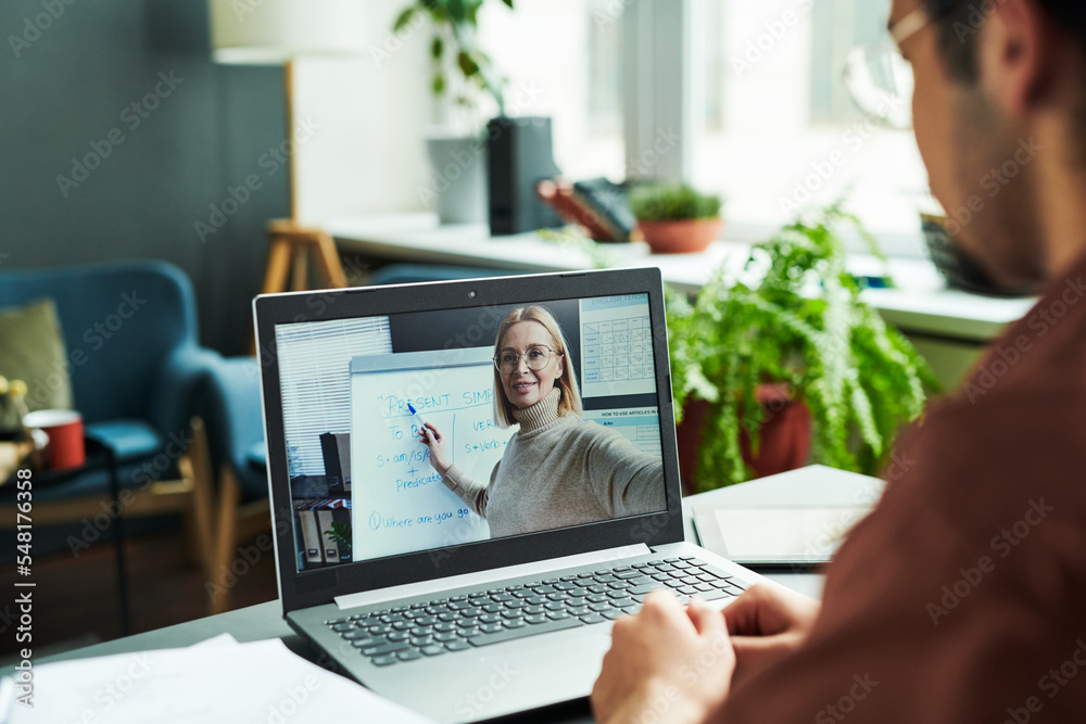 Laptop screen with mature blond confident teacher in eyeglasses ...