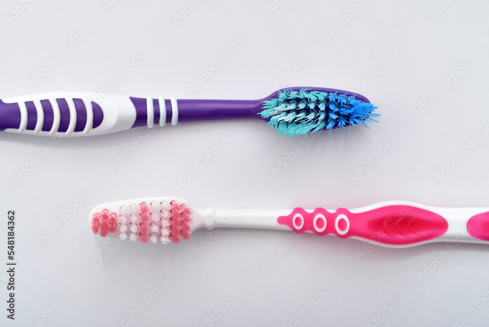 Old and new toothbrush isolated on the pale blue background. Compared ...