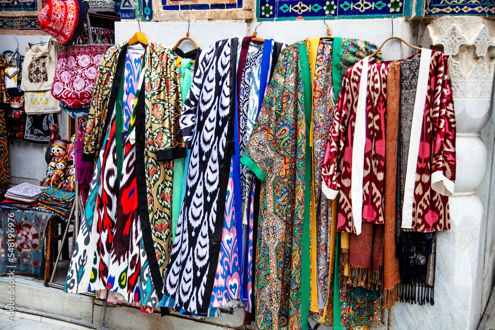 Uzbek traditional clothes such as robes and other colorful souvenirs ...